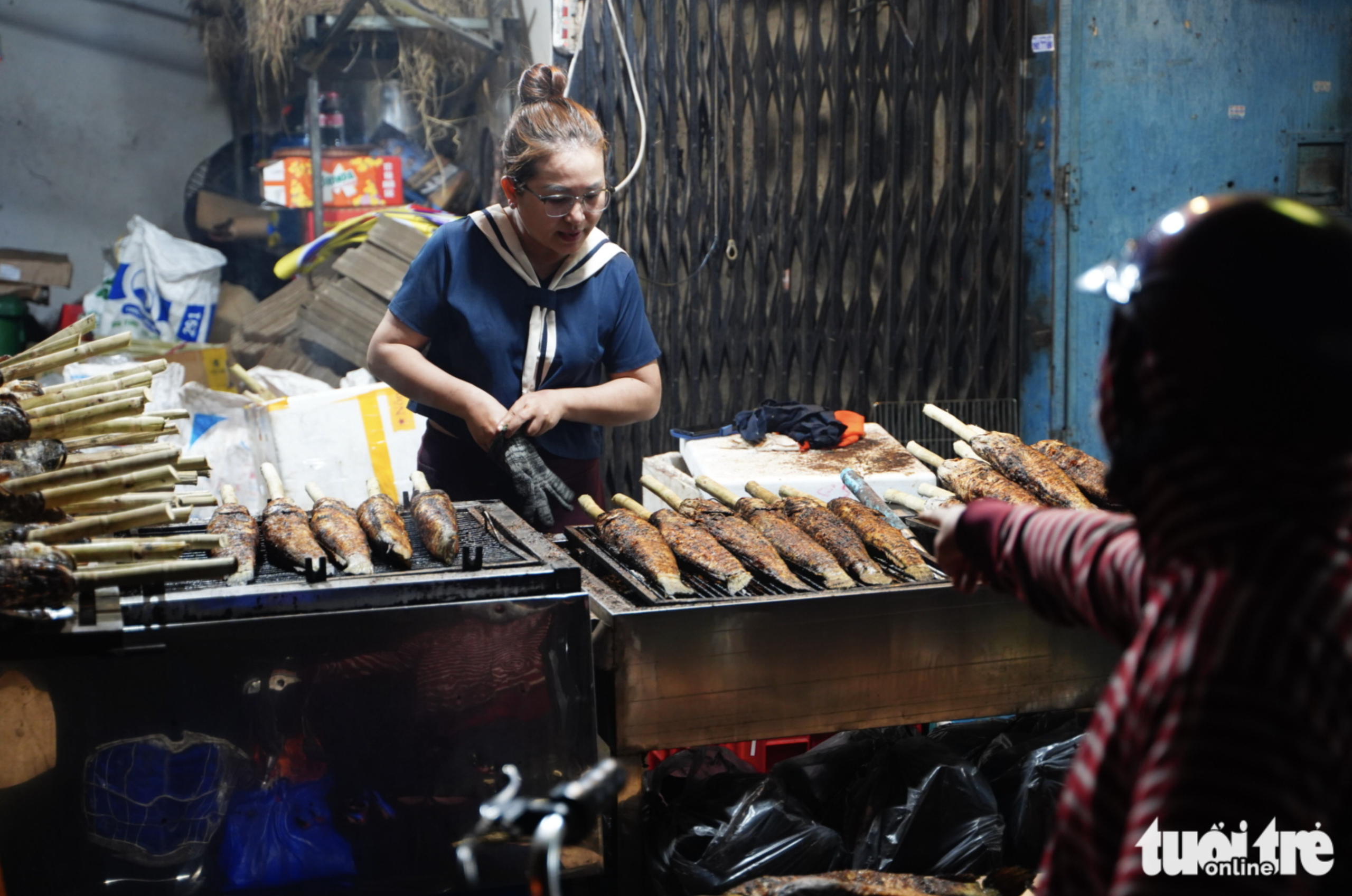 Charcoal burns overnight as vendors prepare grilled snakehead fish for ...